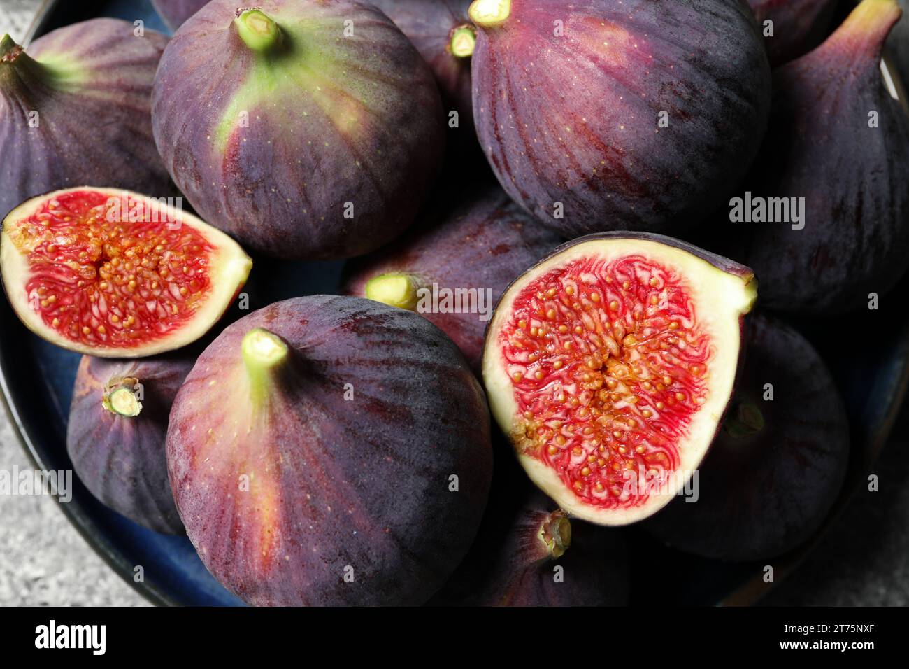 Whole and cut ripe figs on light grey table, top view Stock Photo - Alamy