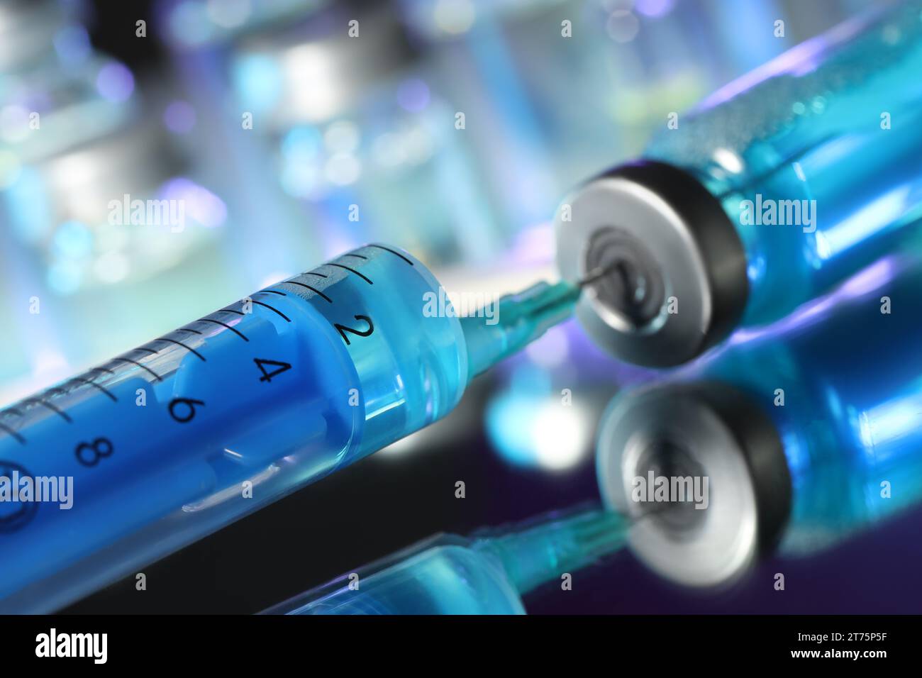 Filling syringe with medicine from vial on mirror surface, closeup ...