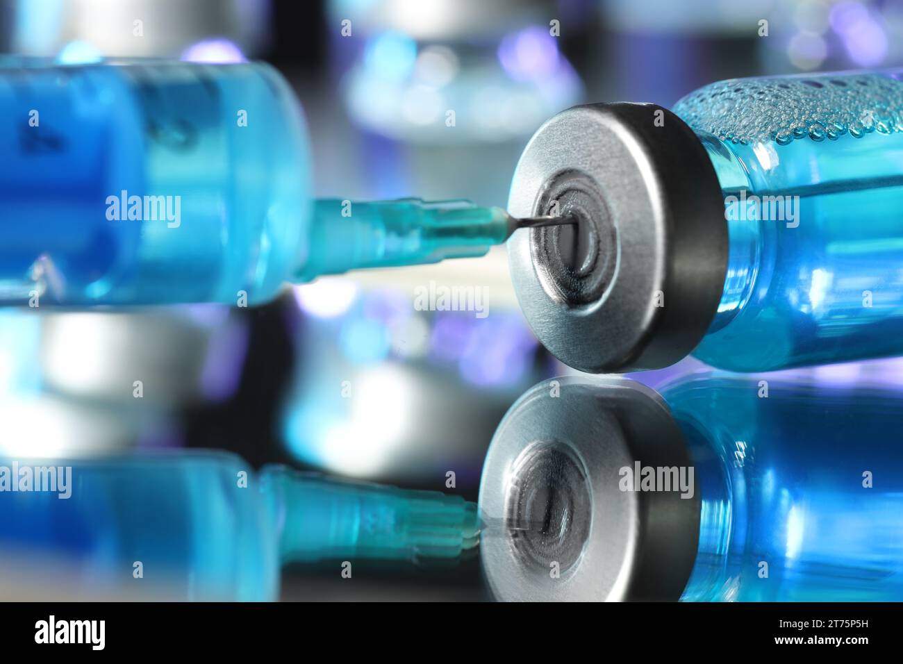 Filling syringe with medicine from vial on mirror surface, closeup ...