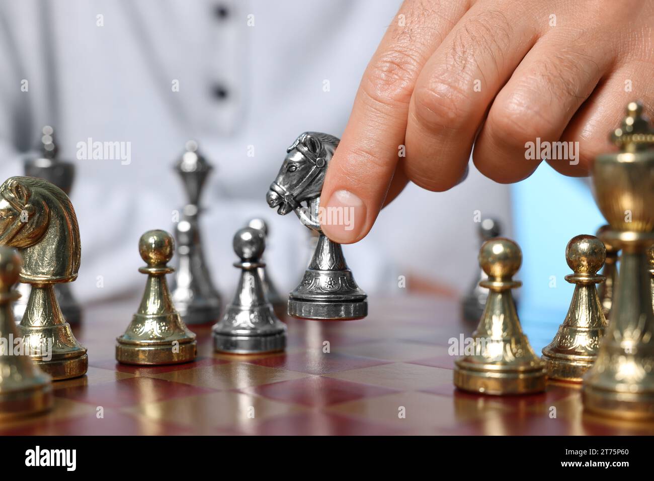 Man with knight playing chess at checkerboard, closeup Stock Photo - Alamy