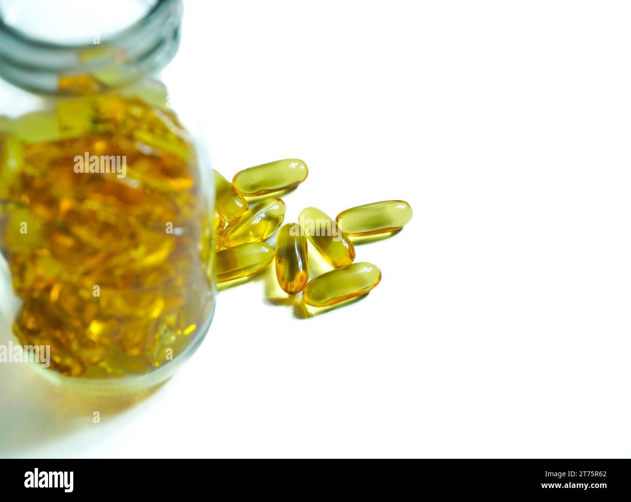 Fish Oil supplement capsules for health spill out from clear glass ...