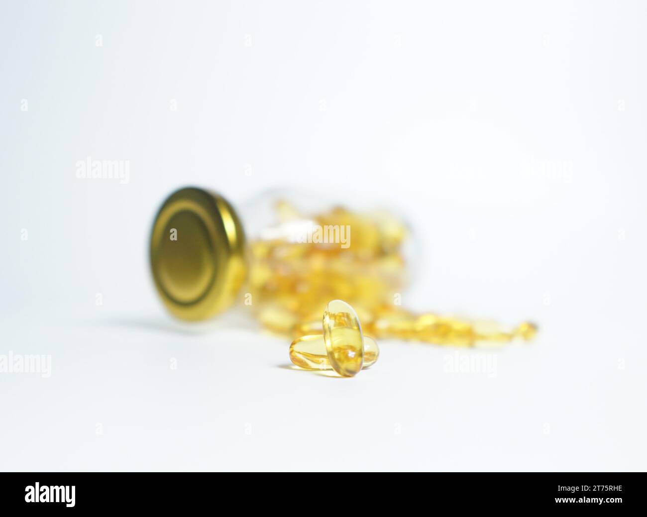 Fish Oil supplement capsules for health spill out from clear glass ...