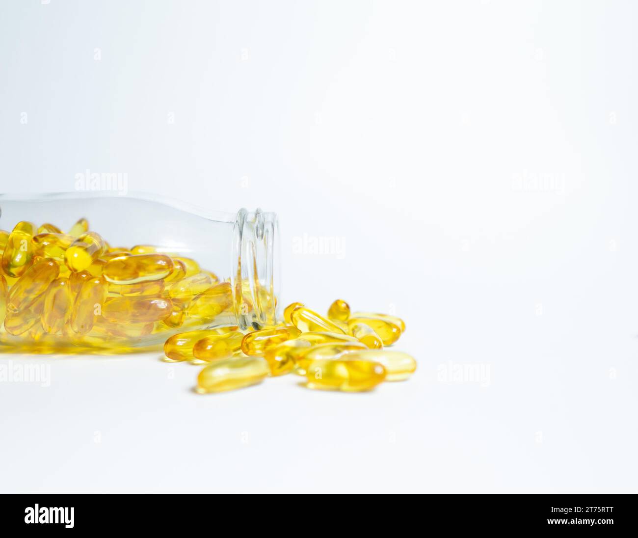 Fish Oil supplement capsules for health spill out from clear glass ...