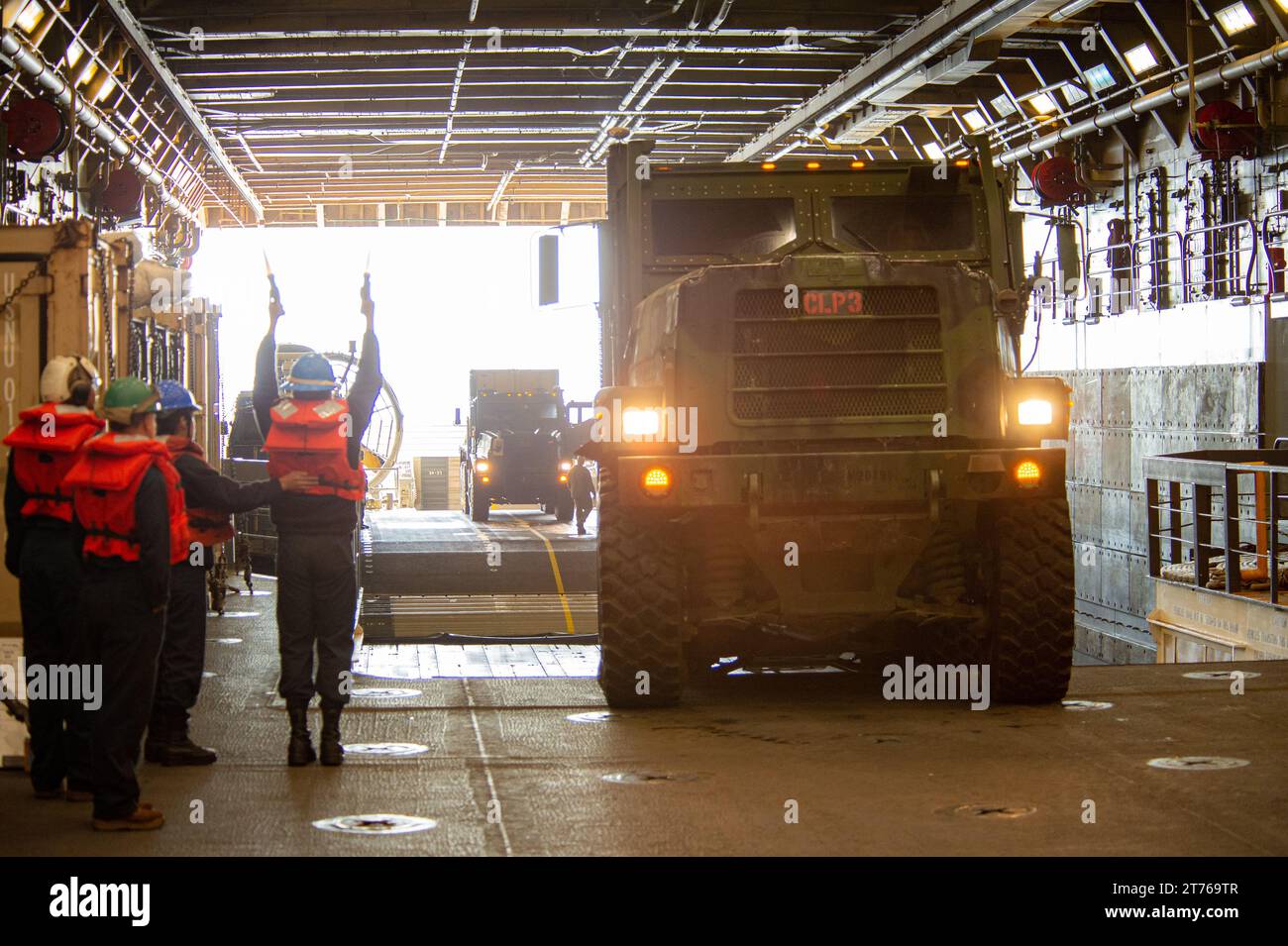 Sailors signal a medium tactical vehicle replacement, assigned to the ...