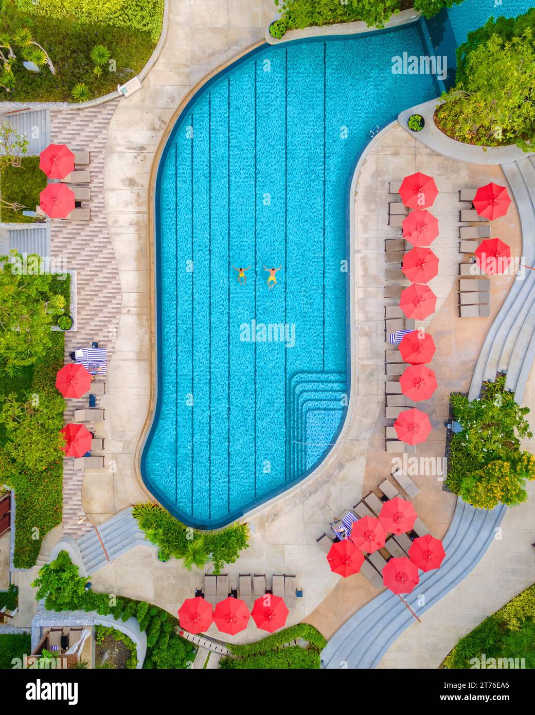 drone view from above at a couple swimming in an pool on a luxury ...