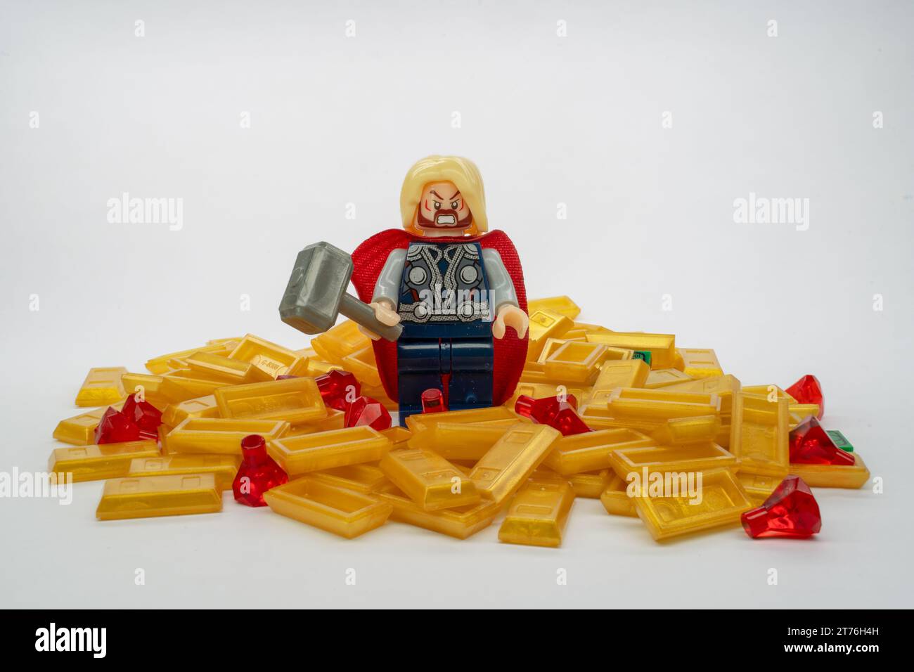 A miniature toy figurine standing upon a stack of golden blocks ...