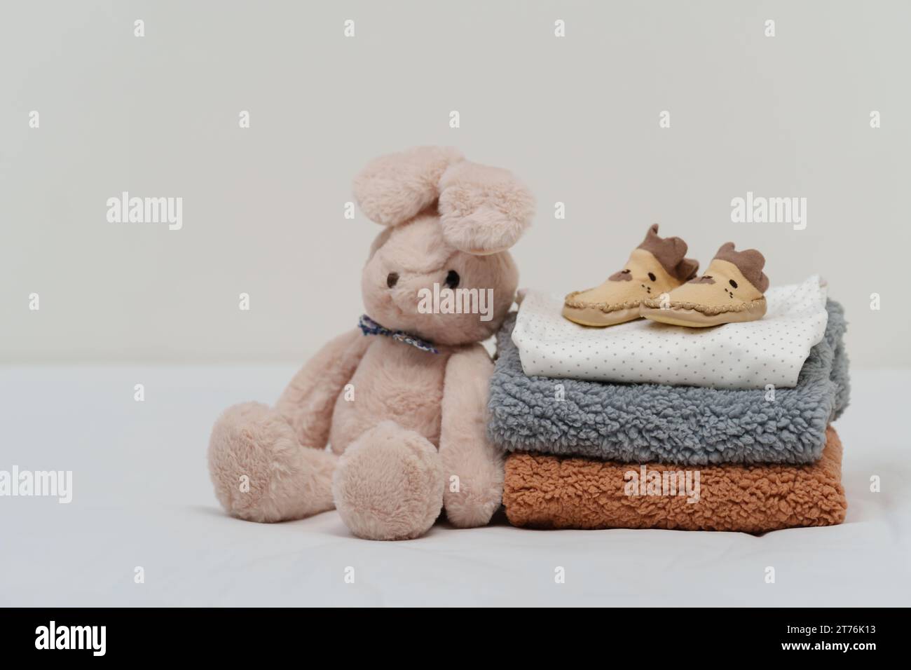 stack of baby clothes and shoes and toy on a bed Stock Photo - Alamy