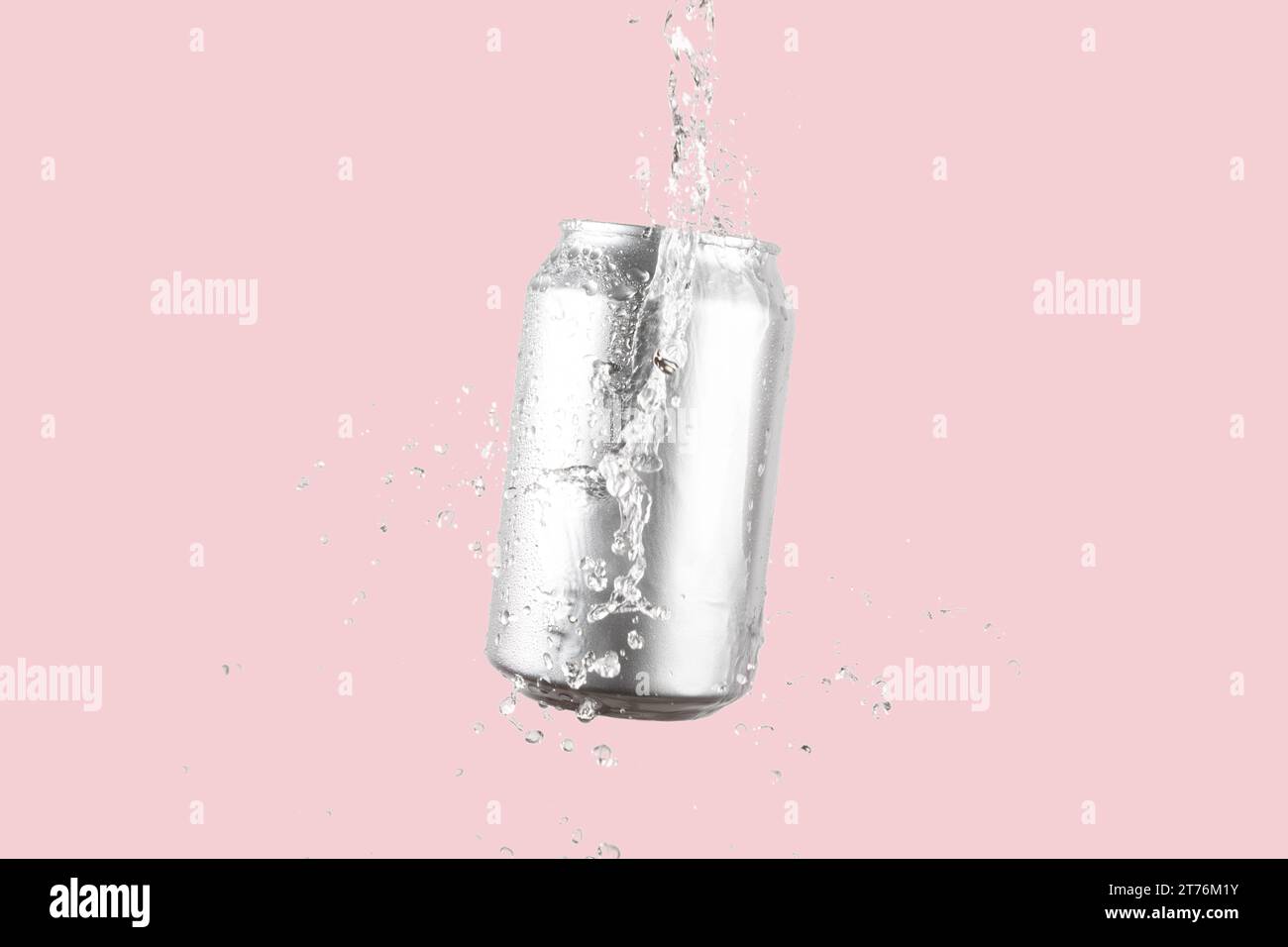 Aluminium beer or soda drinking can with water splash on light pink ...