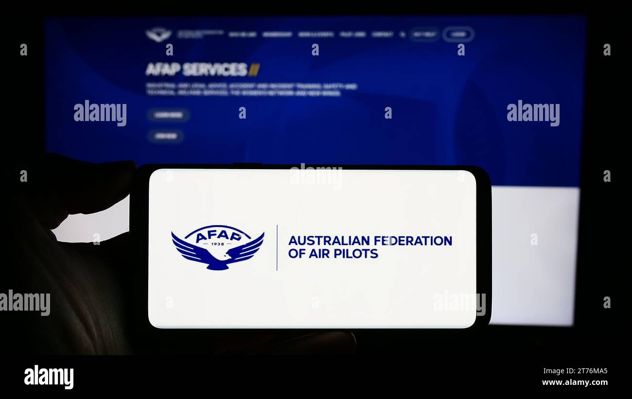 Person holding mobile phone with logo of association Australian Federation of Air Pilots (AFAP ...