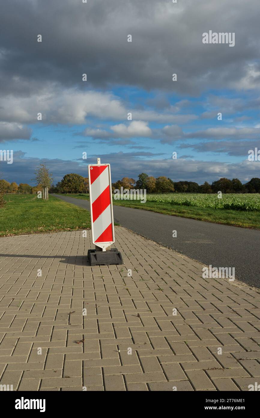 A construction site warning sign stands alone on a small road Stock ...