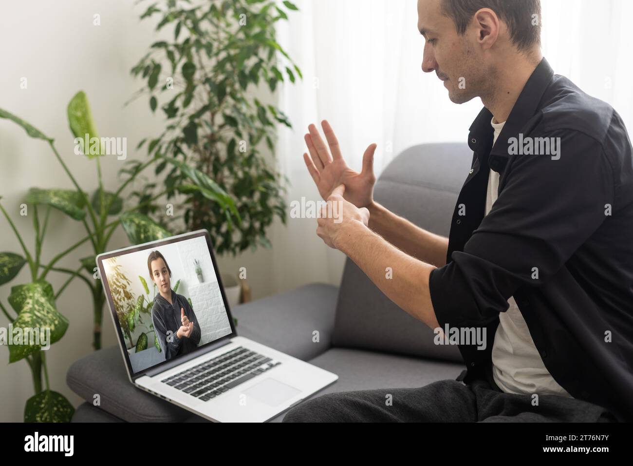 Young man showing gesture in sign language using laptop, make video ...
