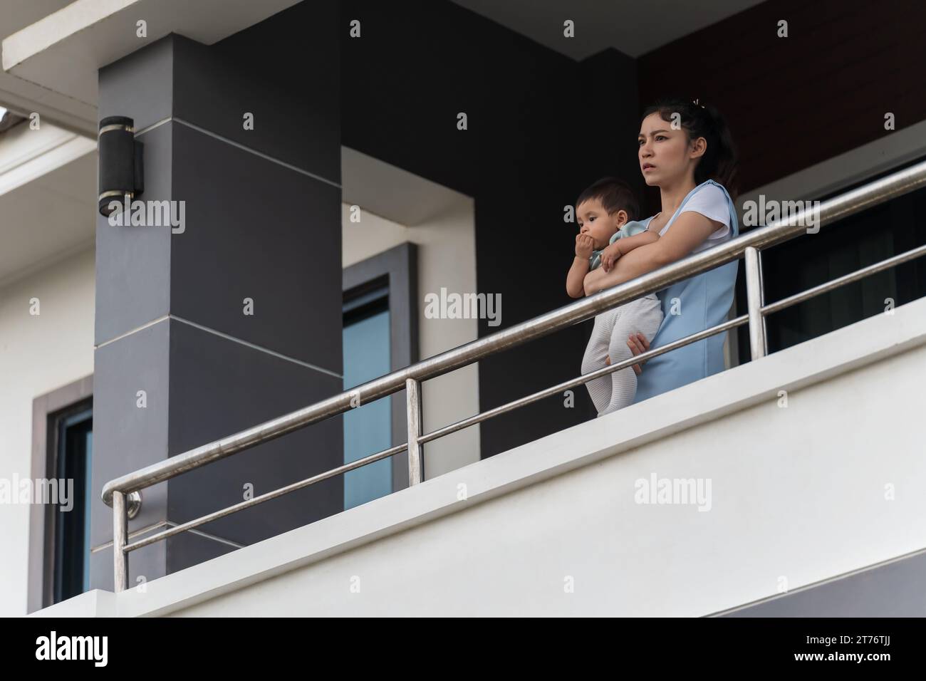 stressed mother and infant baby at balcony of their house Stock Photo ...