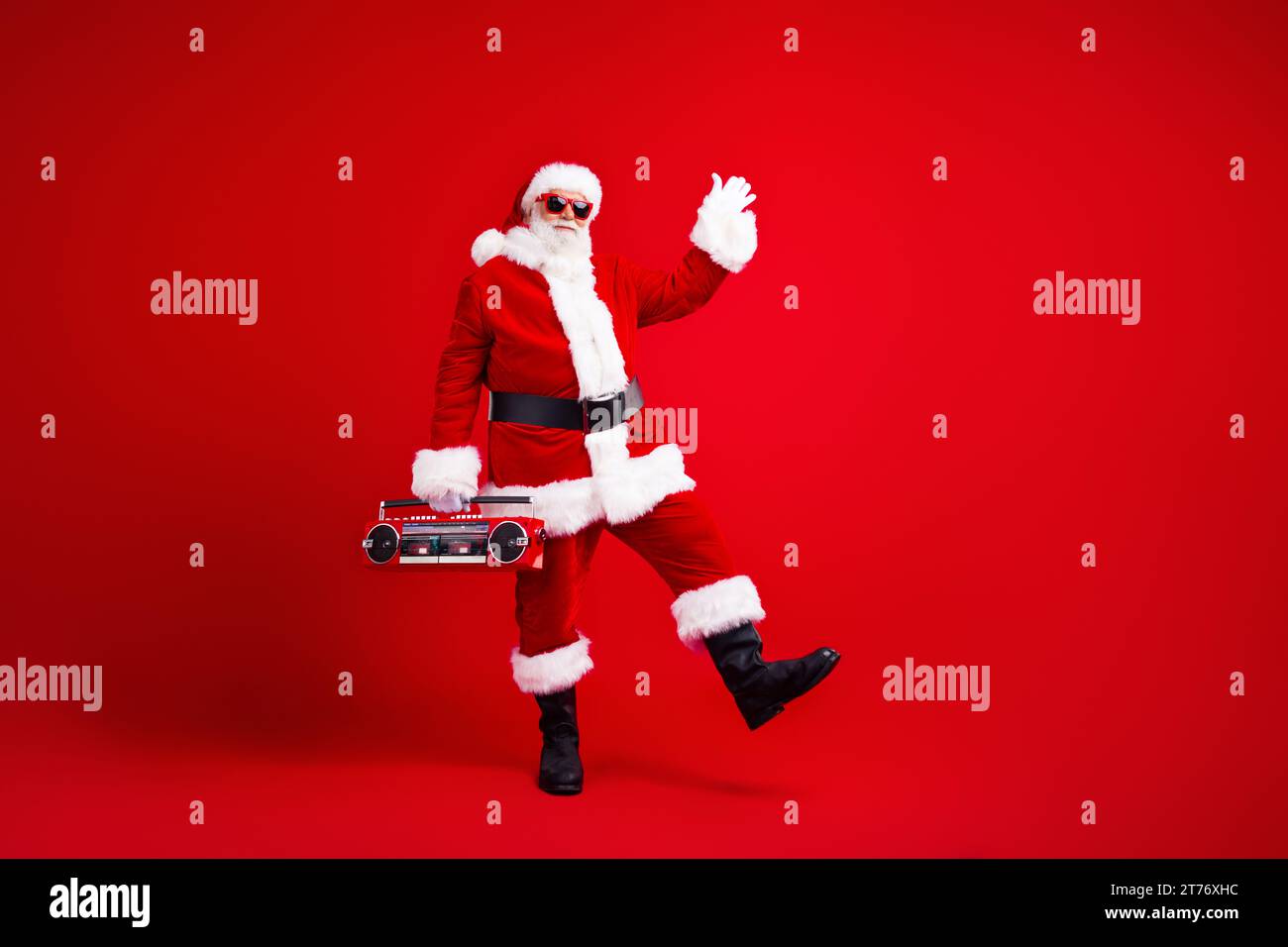 Full length photo of optimistic santa claus in sunglass waving palm say ...