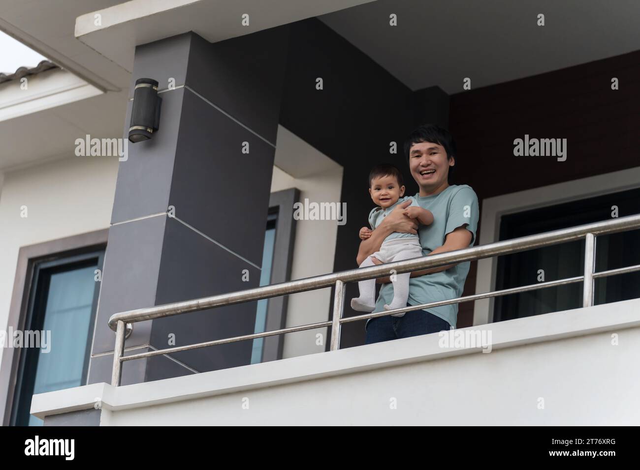 happy father and infant baby at balcony of their house Stock Photo - Alamy