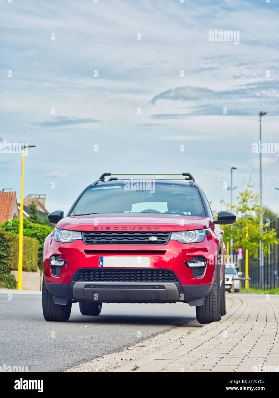 A vibrant red Discovery SUV parked along a city street, highlighting ...