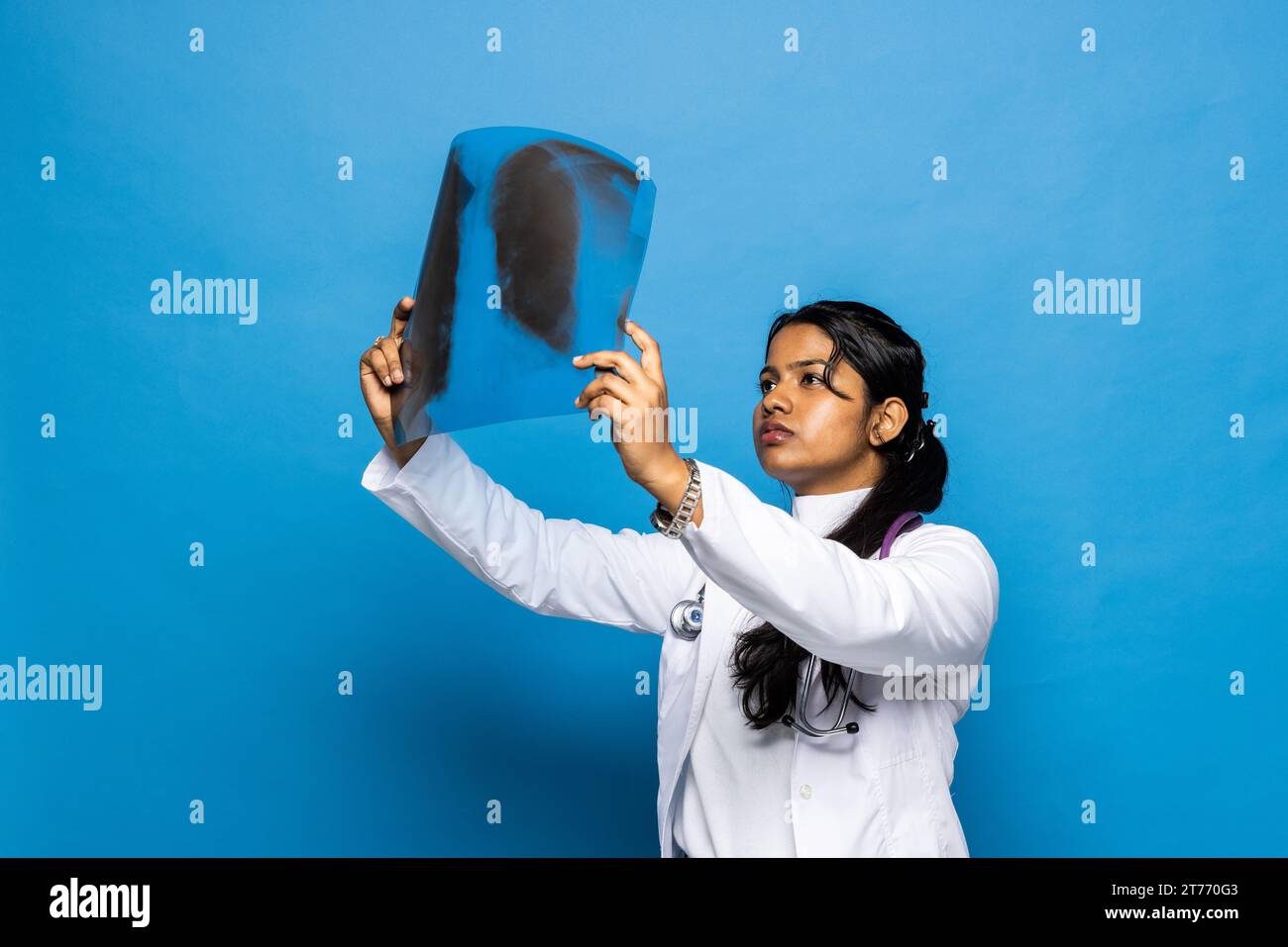Portrait of a young female doctor examining patient's x-rays scan ...
