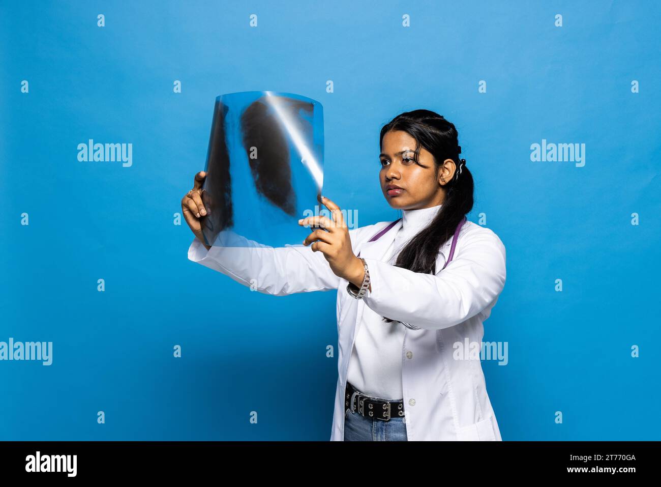 Portrait of a young female doctor examining patient's x-rays scan ...
