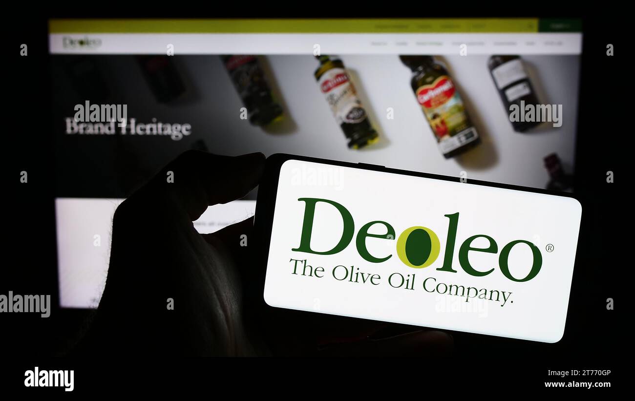 Person holding smartphone with logo of Spanish oilve oil processing ...