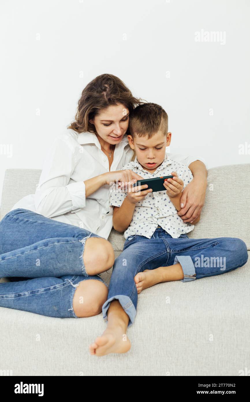 baby and mom plays in phone uses internet on smartphone Stock Photo - Alamy