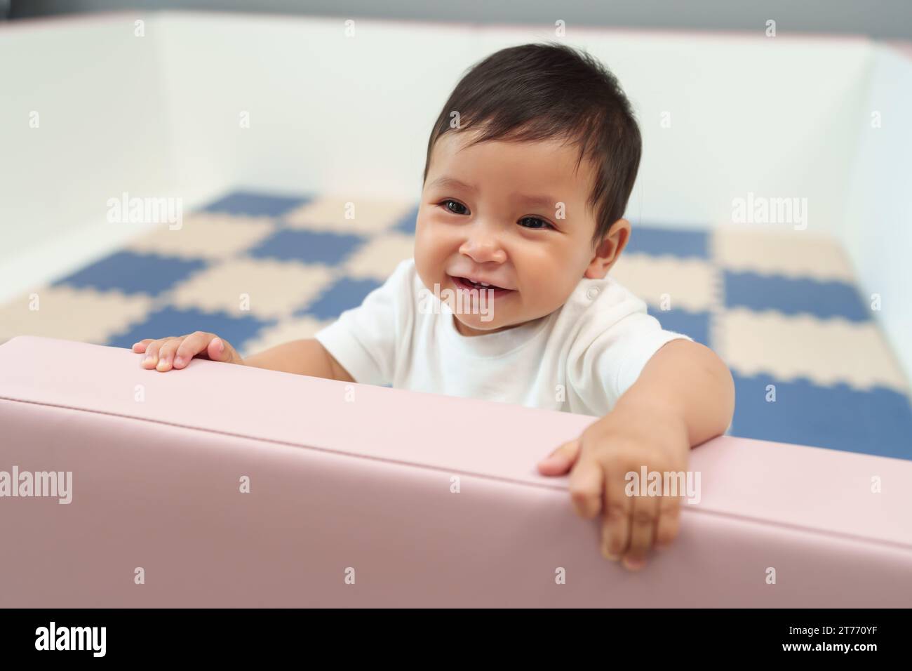 happy infant baby standing in a fence of playpen Stock Photo - Alamy