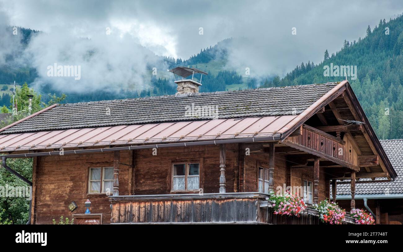 Traditional wooden building with balconies & flower boxes, low clouds ...