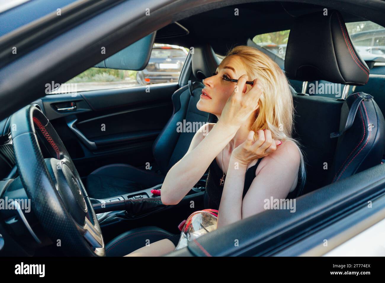 woman does makeup behind the wheel of a car Stock Photo - Alamy