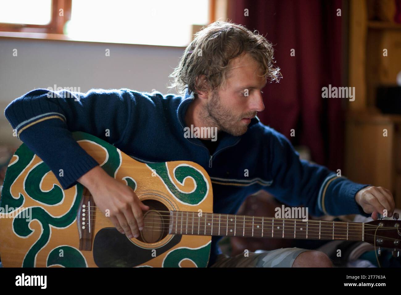 Man adjusting an acoustic guitar Stock Photo - Alamy