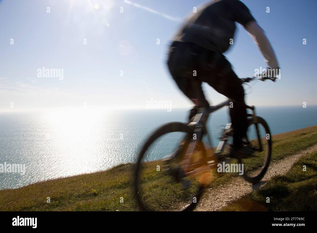 Back view of a man cycling on a costal path by the ocean Stock Photo ...