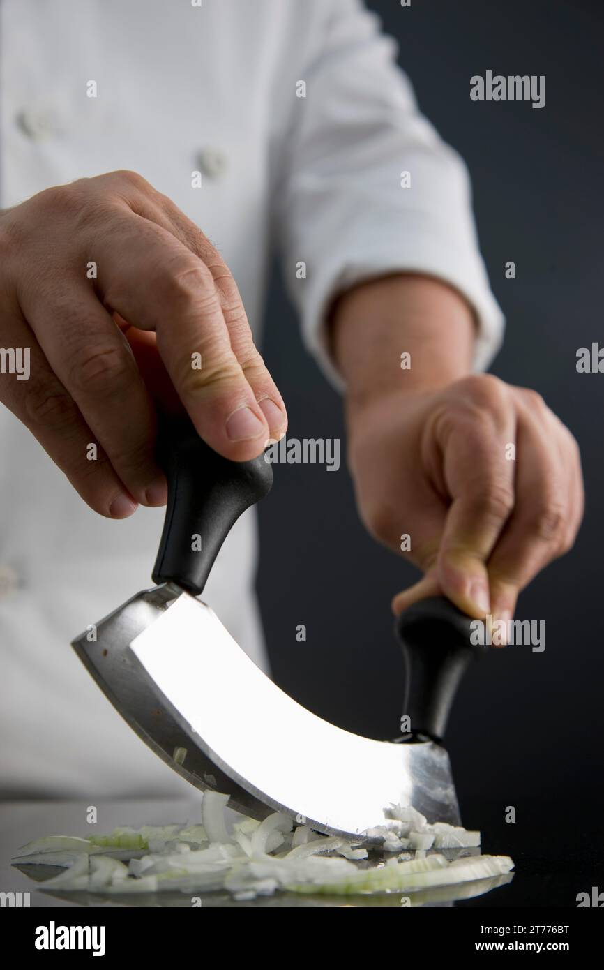 Close up of a chef hands chopping an onion with a double blade ...