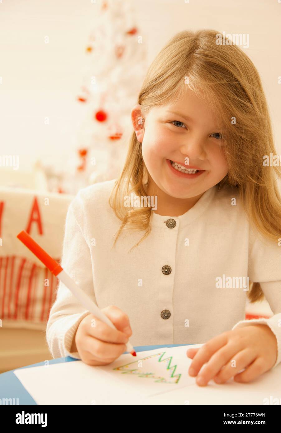 Smiling girl writing a letter to Father Christmas Stock Photo - Alamy