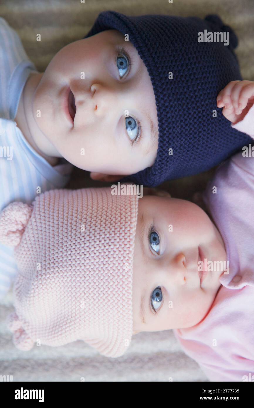 Elevated View of Twin Babies Lying on Back Facing Opposite Directions ...