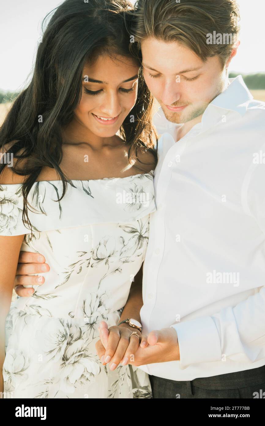 Man Holding Woman's Hand Looking at Engagement Ring Stock Photo - Alamy