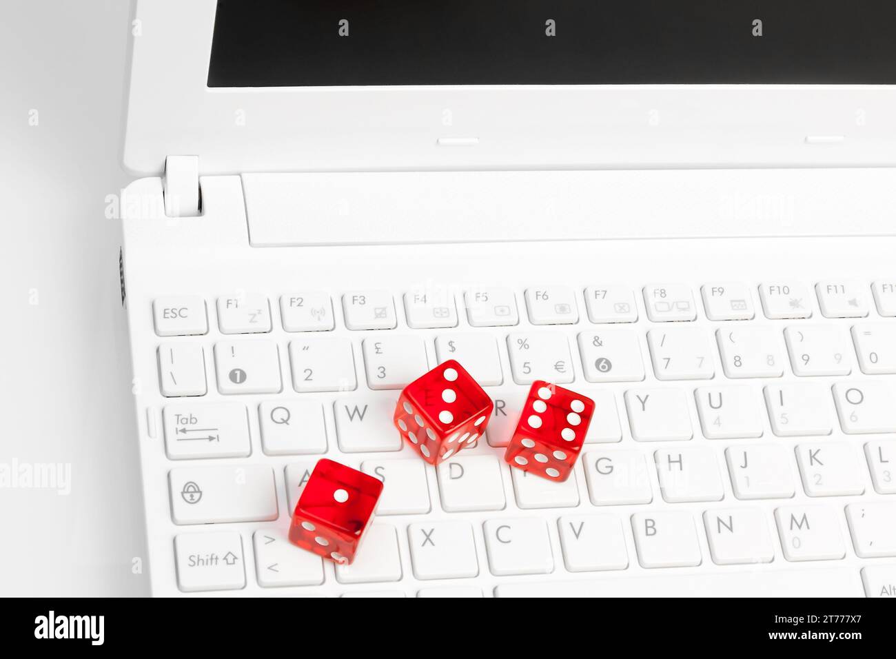 a computer keyboard with three red dice Stock Photo - Alamy