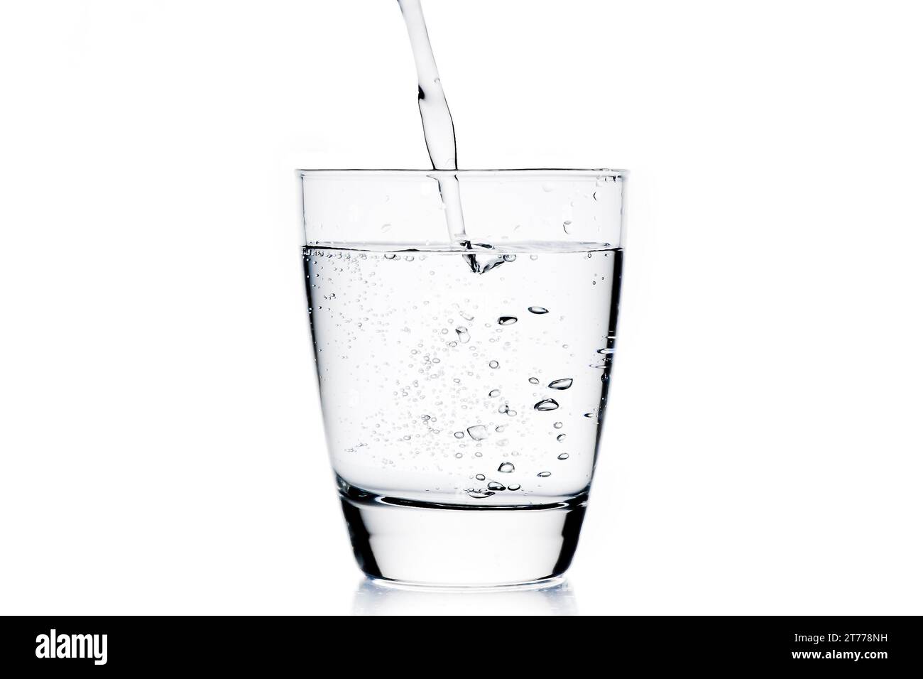 filling a glass with pure water on white background Stock Photo - Alamy