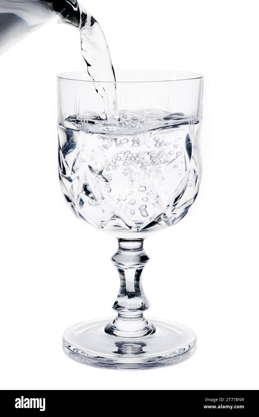 filling a glass with pure water on white background Stock Photo - Alamy