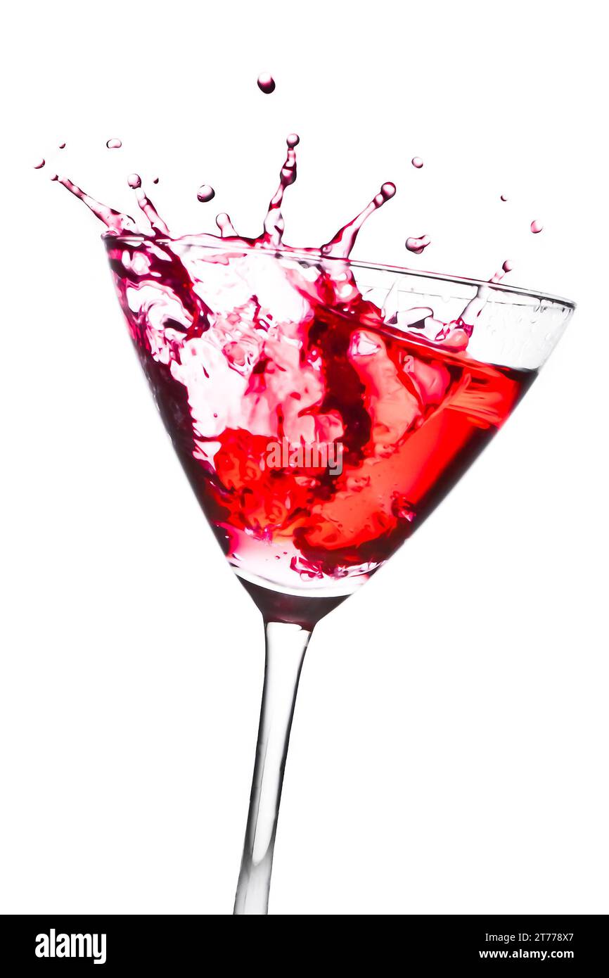 red cocktail with splashing in the tilted glass on a white background ...