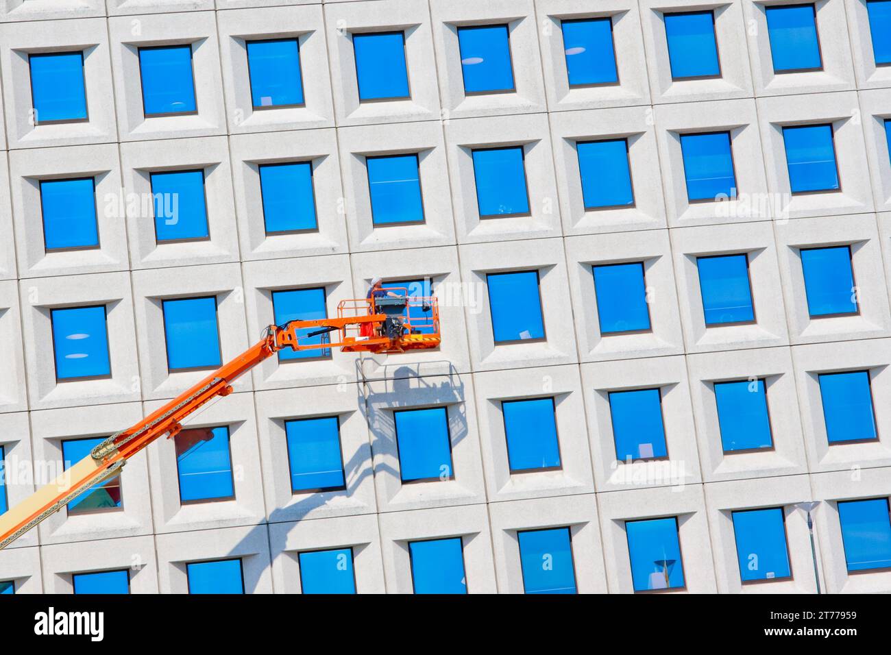 worker cleaning high tower with blue glass Stock Photo - Alamy