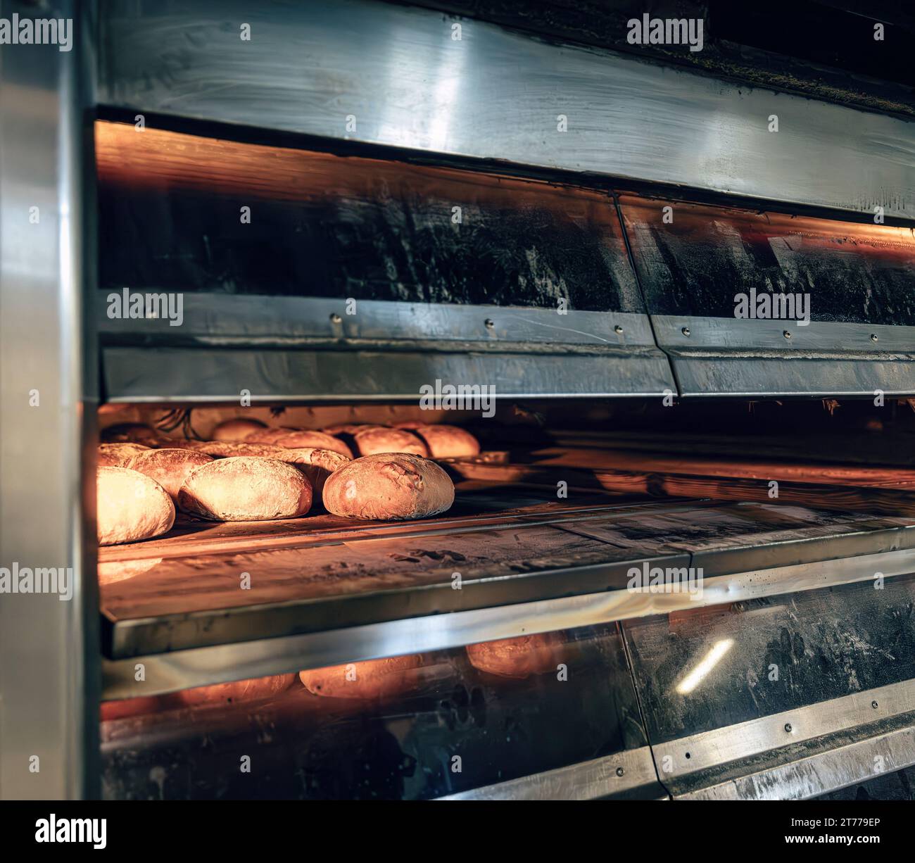 Oven in the bakery. Hot fresh bread leaves the industrial oven in a ...