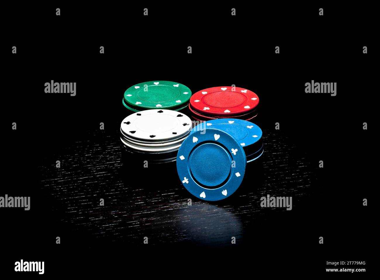 four piles of colorful fiches on black wood table Stock Photo - Alamy