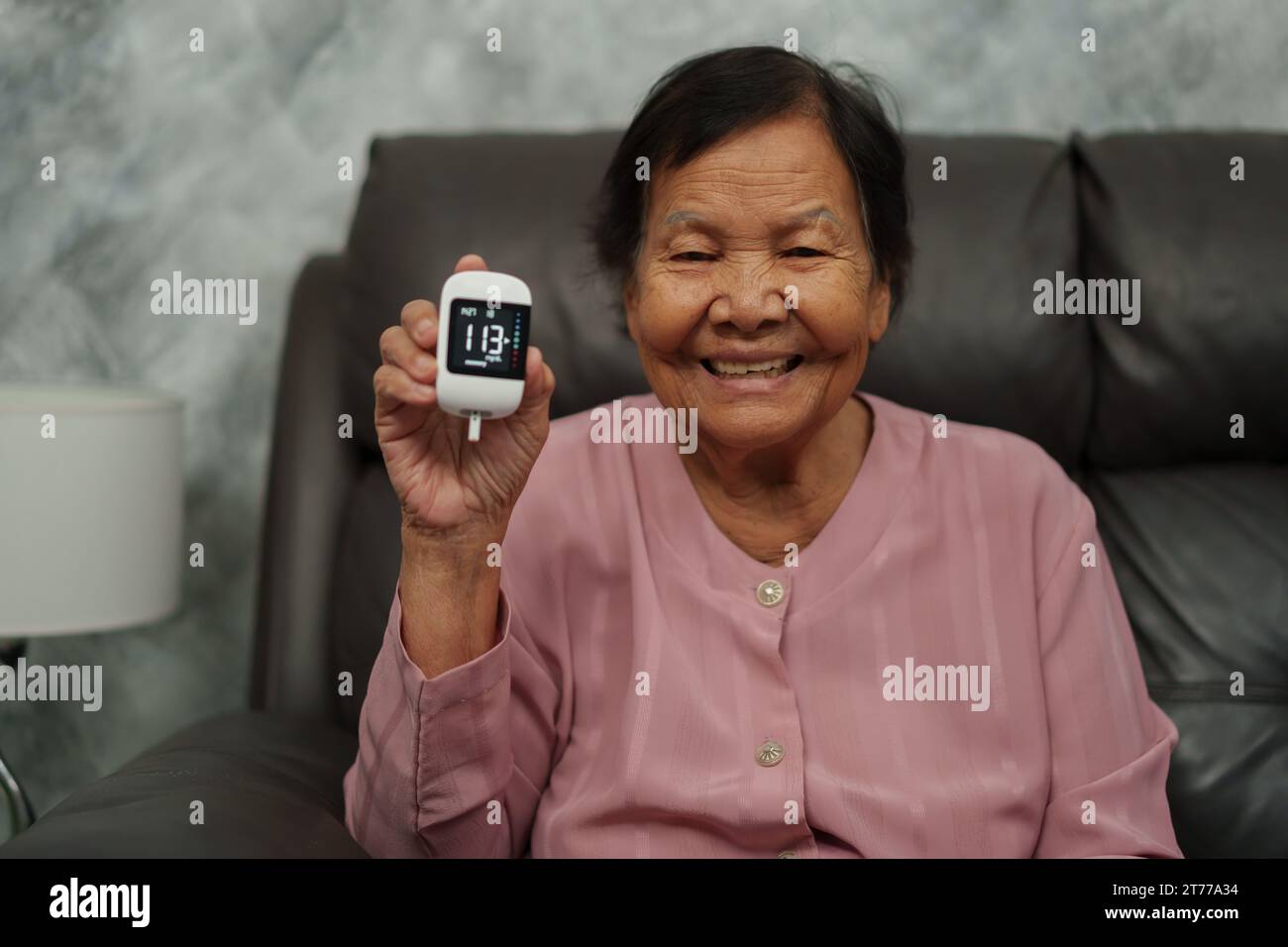 happy senior woman holding glucose meter with result of measurement ...