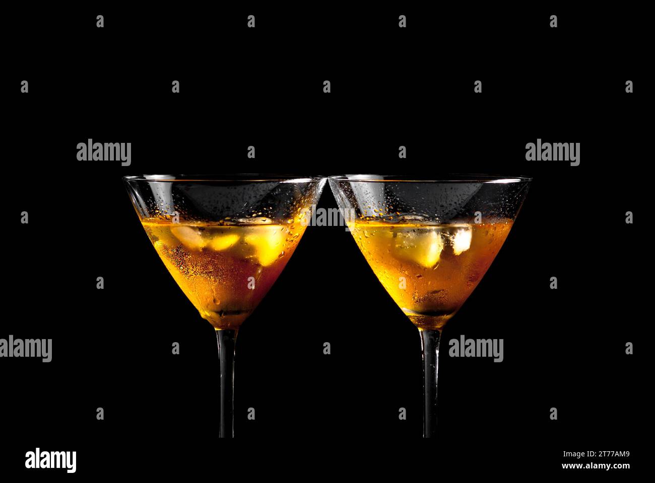 a pair of glasses of fresh cocktail with ice on black background with ...