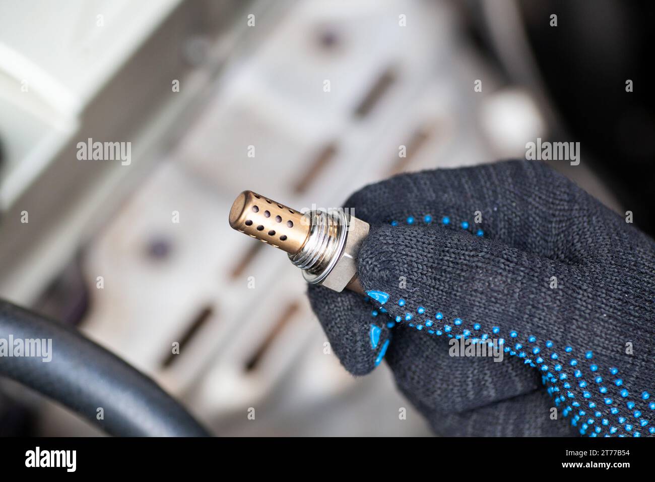 Oxygen sensor for gasoline and diesel engines in the hand against car ...