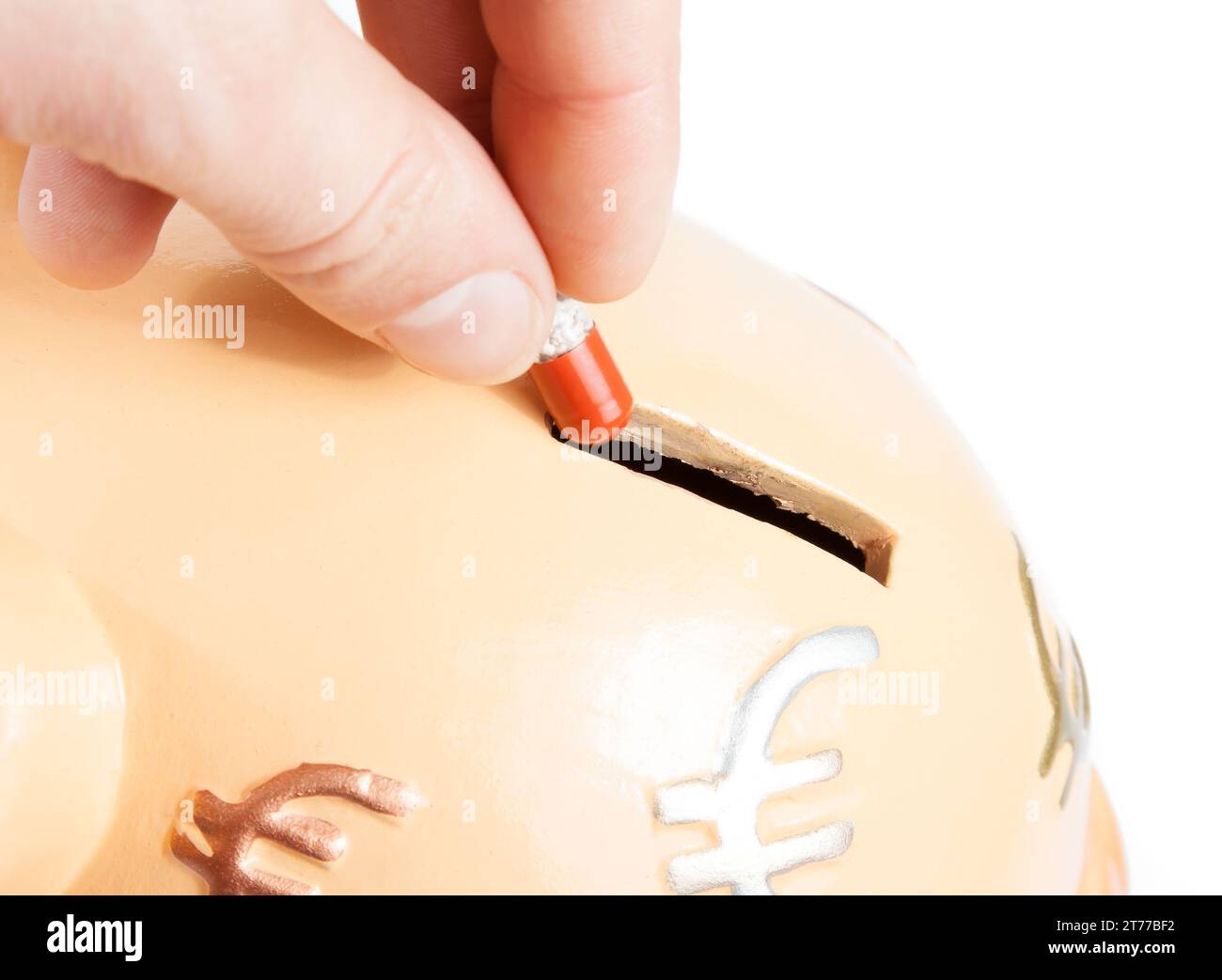 hand inserting a red pill into a piggy bank on white background with ...