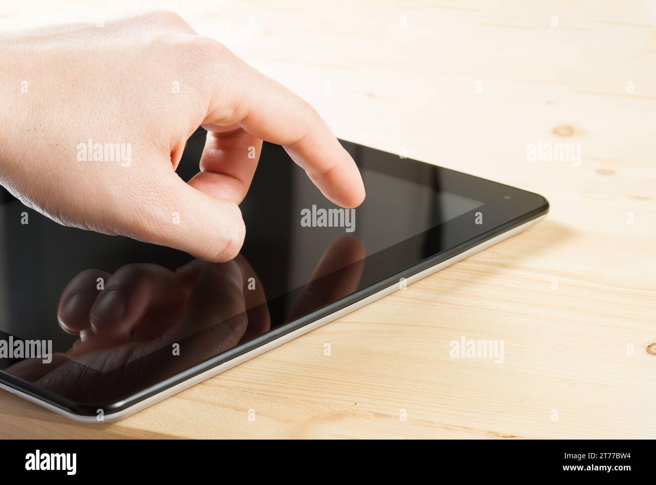 male hand is touching digital tablet pc on wood table with space for ...
