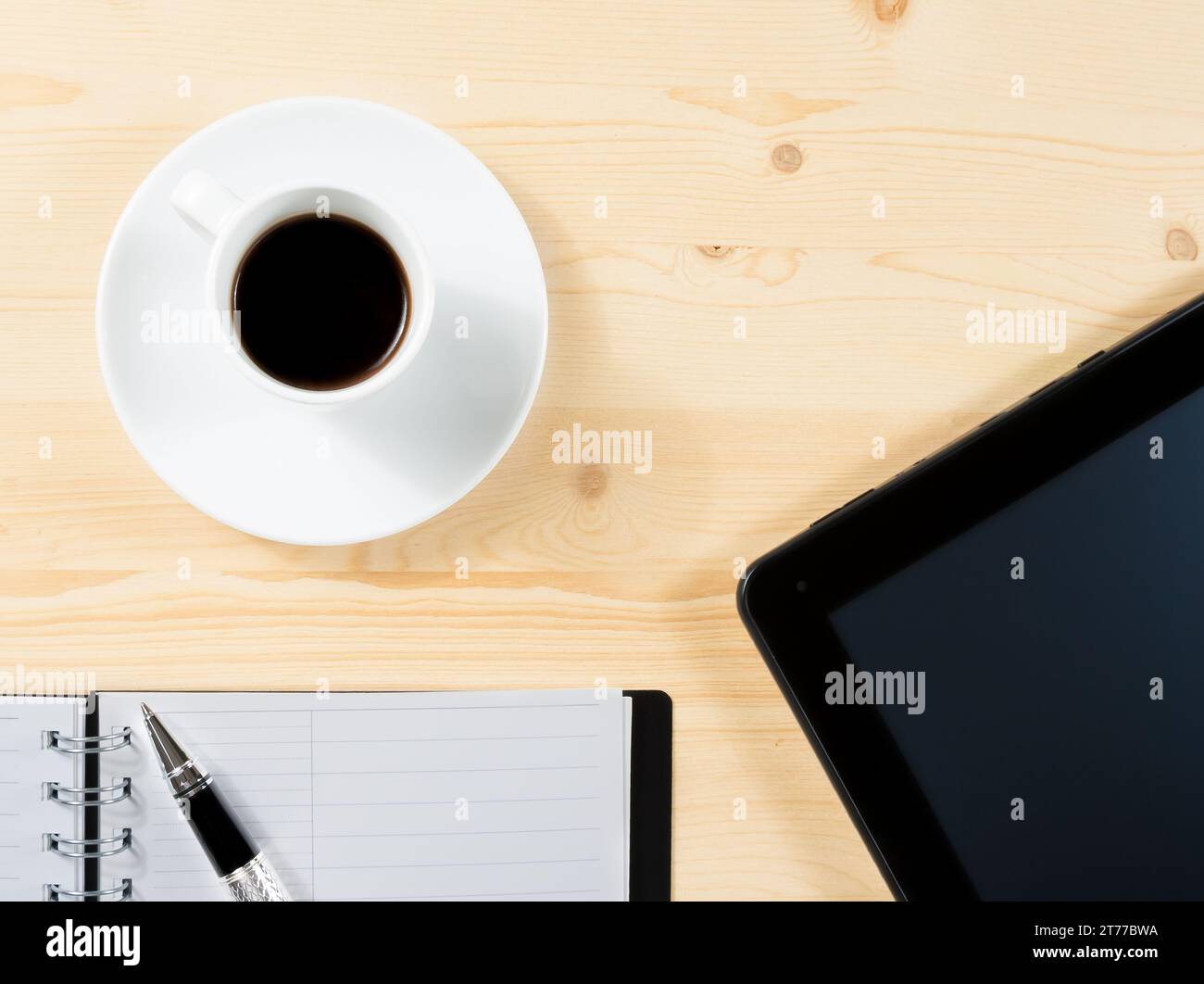 top of view cup of coffee and tablet near notes on wood table, concept ...