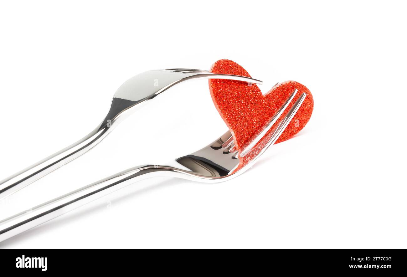 decorative red heart near forks on white background with space for text ...