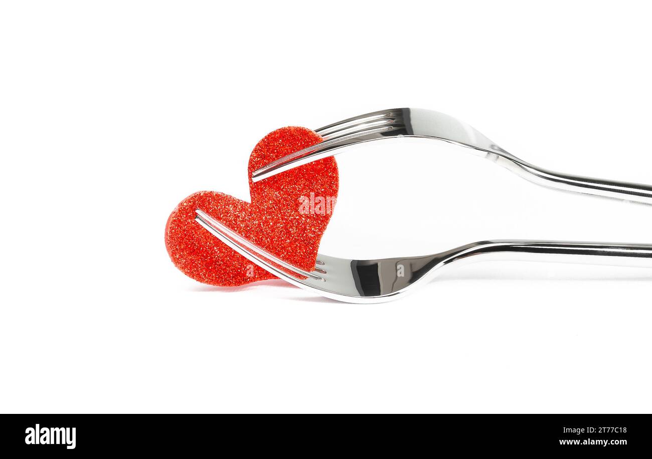 decorative red heart near forks on white background with space for text ...