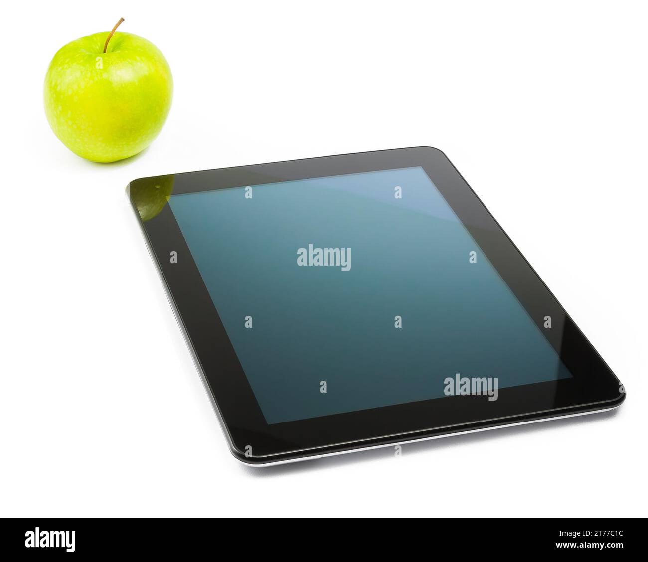 digital tablet pc near green apple on white background, concept of ...