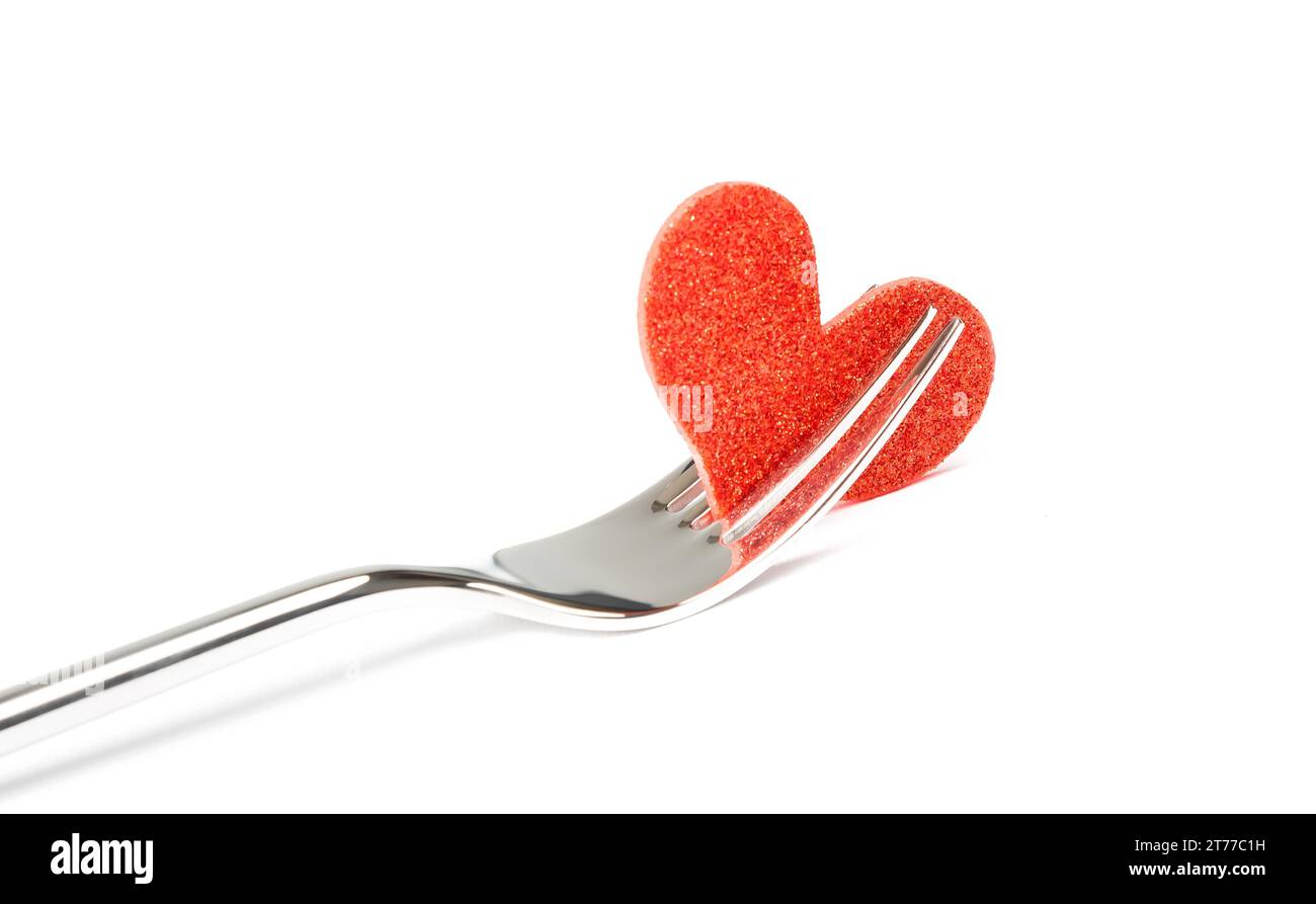 decorative red heart near one fork on white background with space for ...