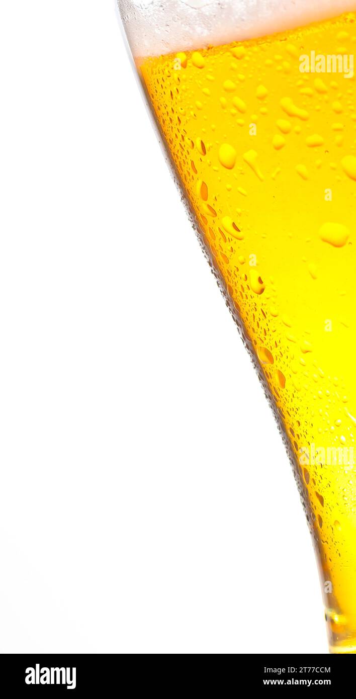 tilted glass of fresh beer with drops on white background, with space ...